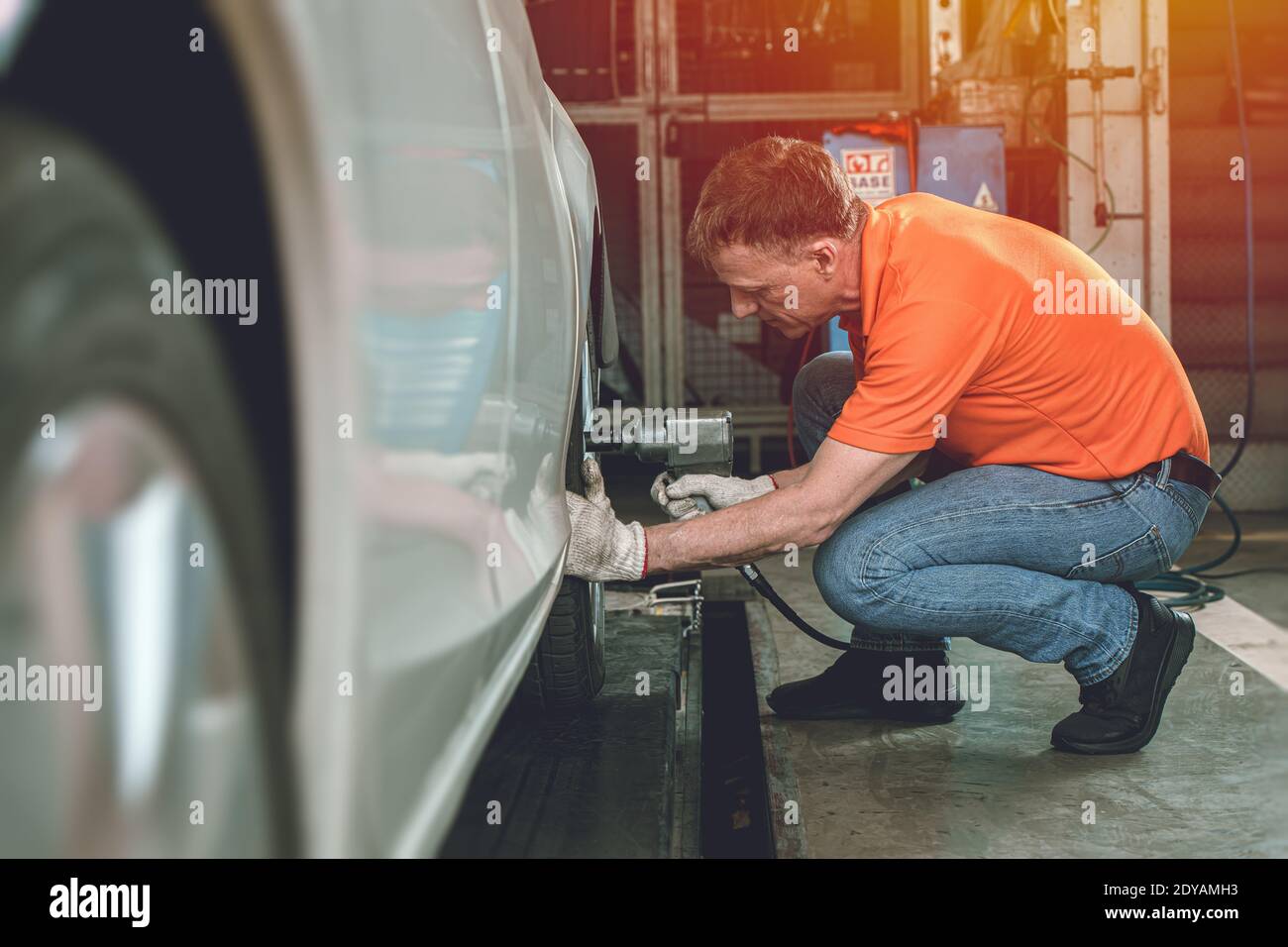 Auto mechanic worker service car by checking inflate or change tires in ...
