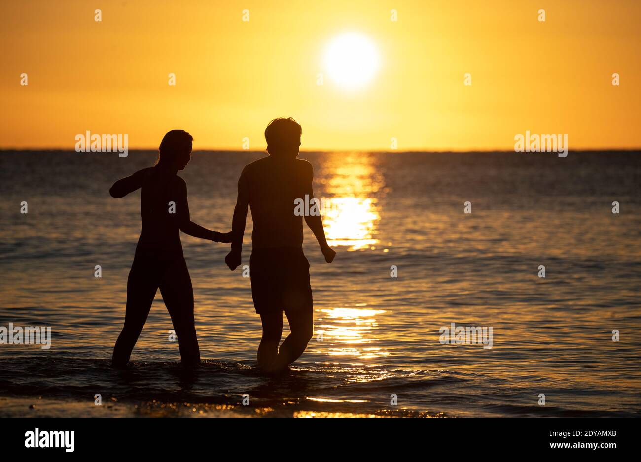Swimmers make their way into the sea off of Boscombe beach in Dorset as ...