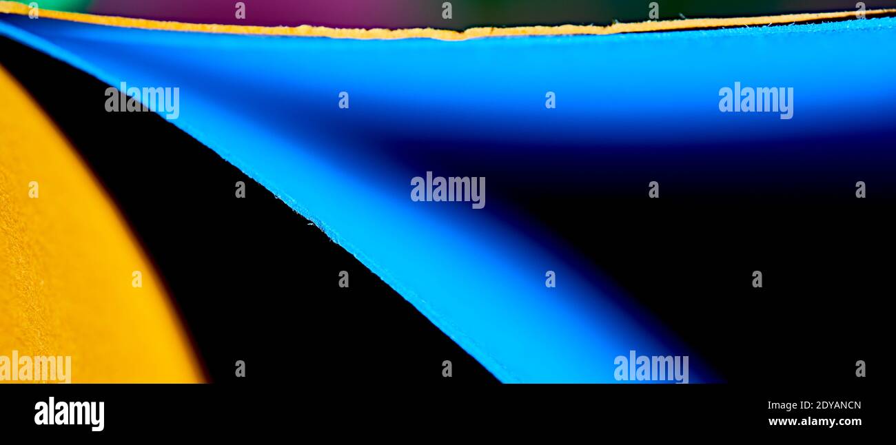Abstract picture of a folded sheet of blue paper in harsh light, taken ...