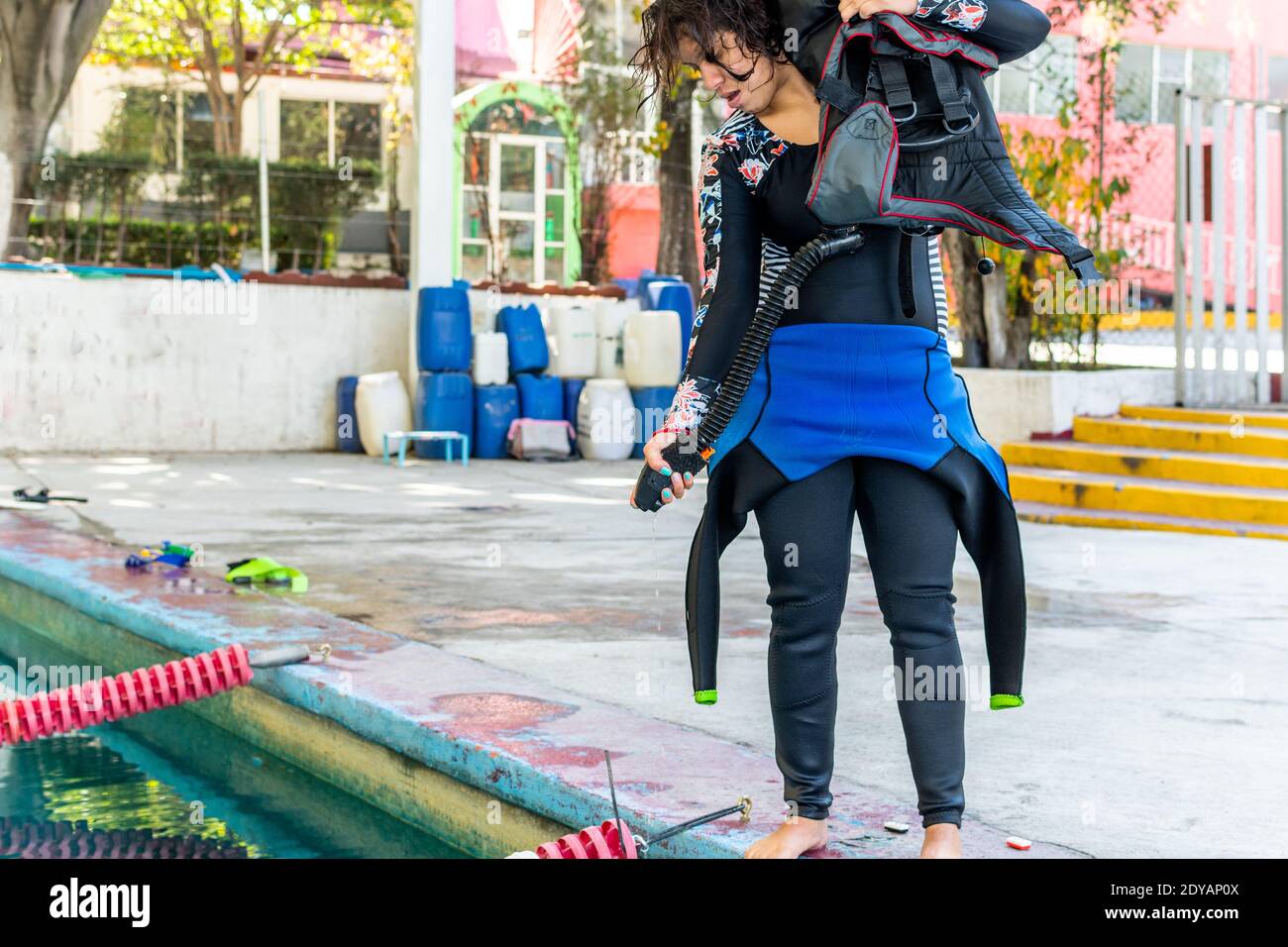 portrait of female diver cleaning her equipment after a diving class ...