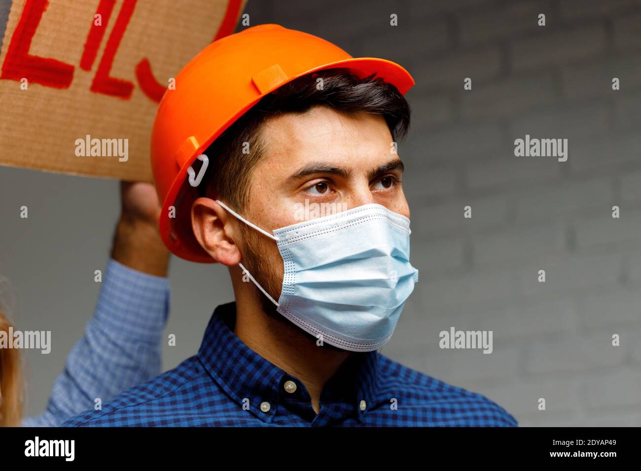 Construction worker with protective mask portrait on grey background ...