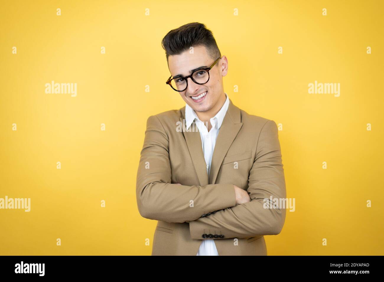 Young business man over isolated yellow background with a happy face ...