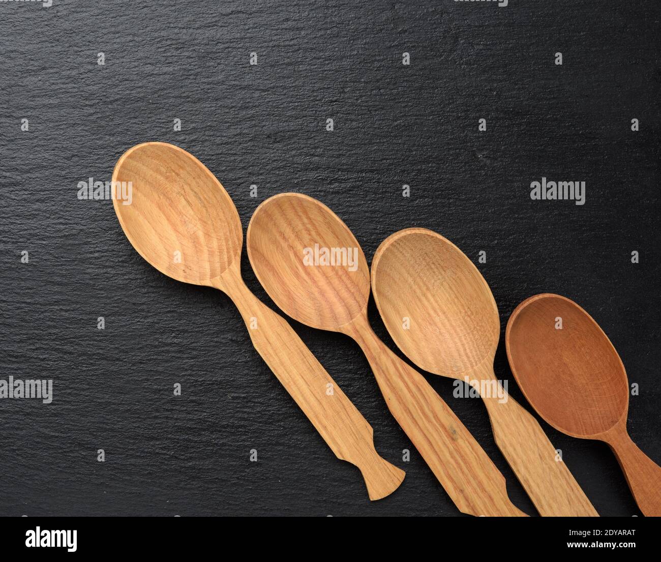 empty wooden spoons on a a black background, top view Stock Photo - Alamy