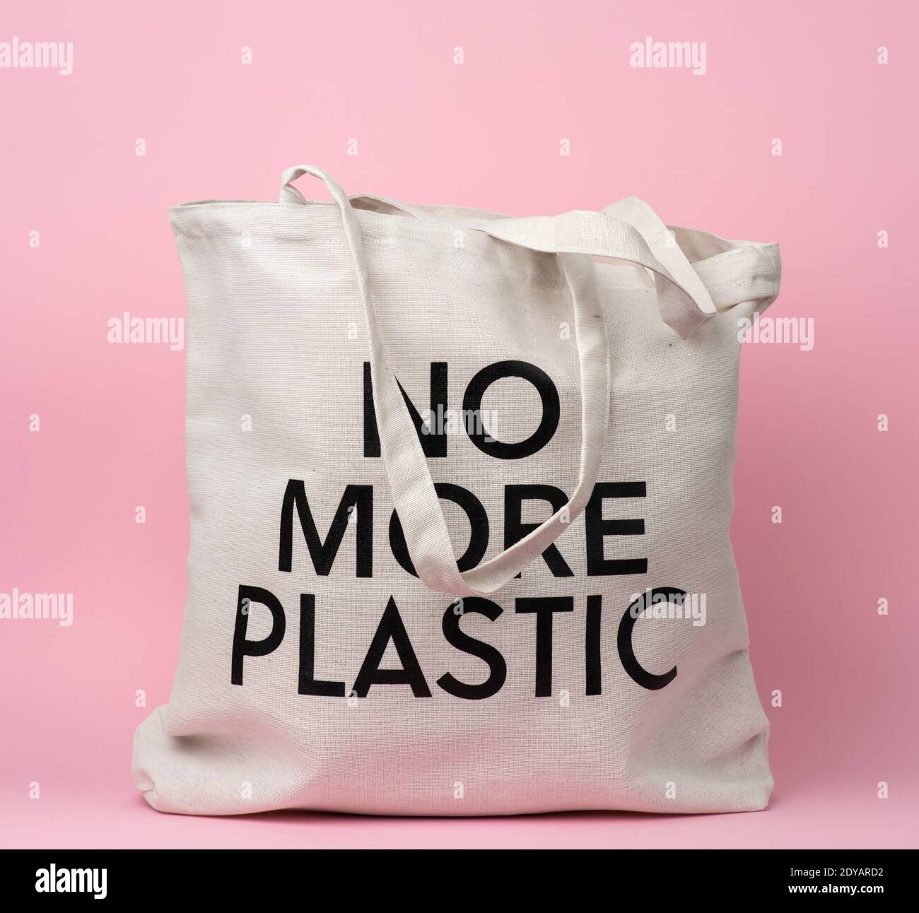 beige textile bag with an inscription no more plastic on a pink ...