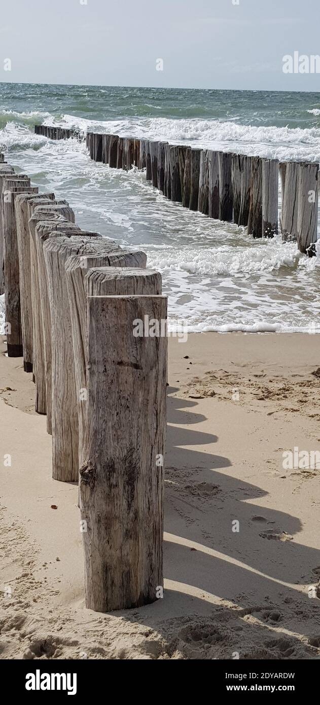 A vertical shot of wooden beach posts and wavy sea Stock Photo - Alamy
