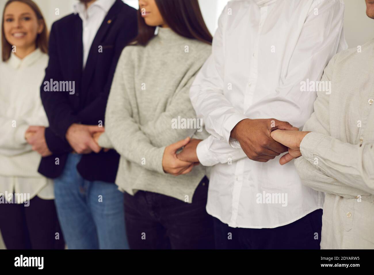 Team of people standing together and holding hands, showing unity and ...