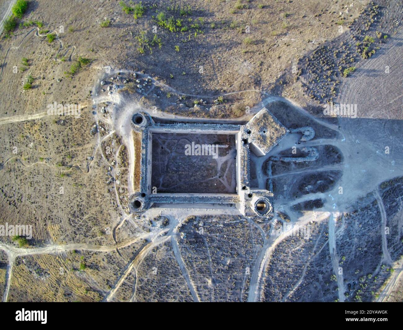 An aerial shot of an ancient ruined castle in the middle of crop fields ...