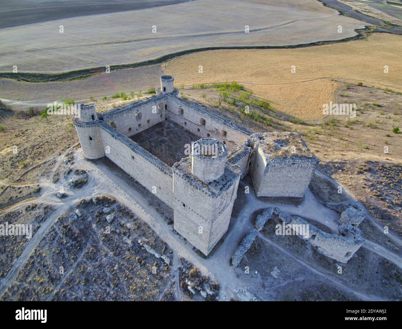 An aerial shot of an ancient ruined castle in the middle of crop fields ...