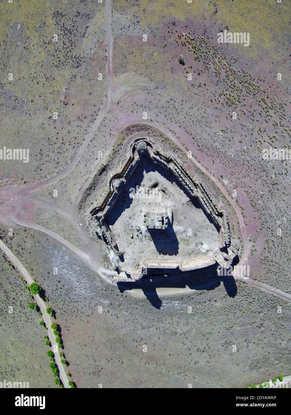 An aerial shot of an ancient ruined castle in the middle of crop fields ...