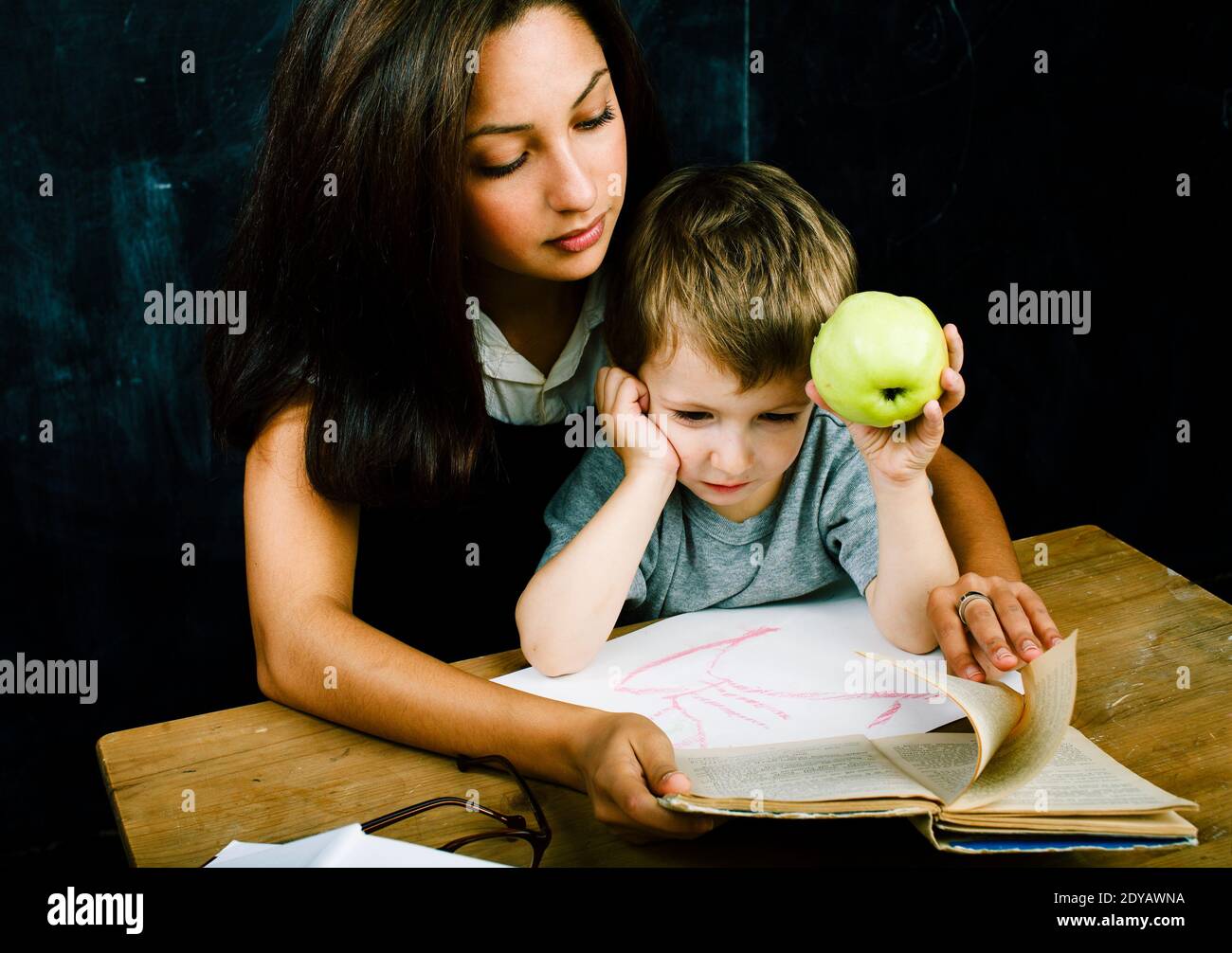 little cute boy in glasses with young real teacher, classroom studying ...