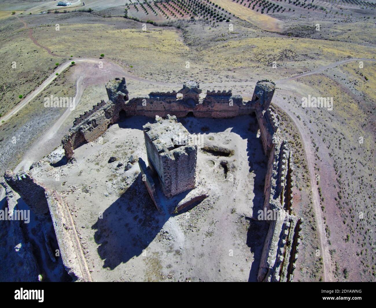 An aerial shot of an ancient ruined castle in the middle of crop fields ...