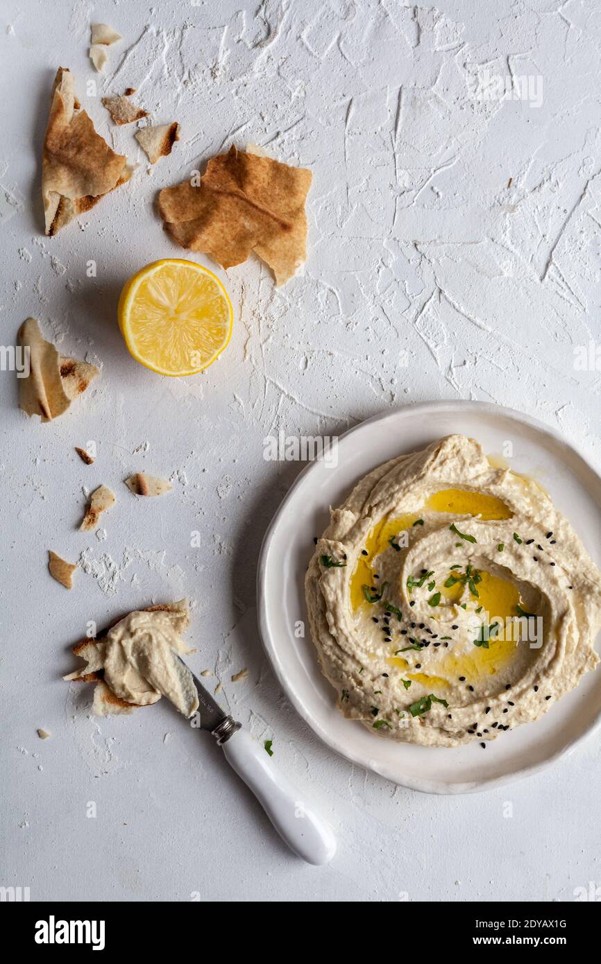 Top down view of a plate of hummus with Lebanese flat bread and lemon ...
