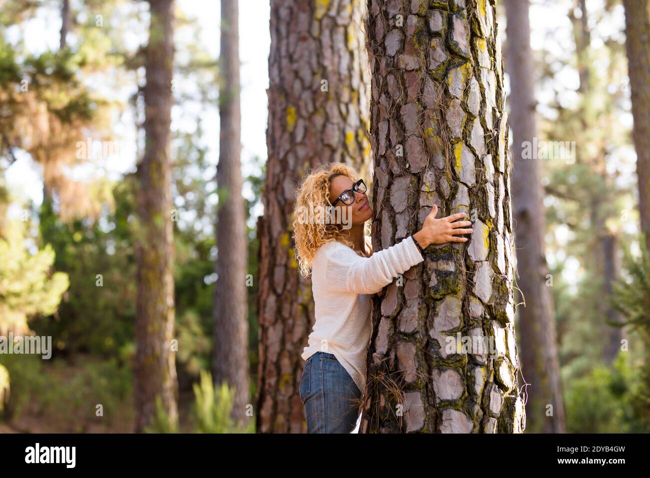 Mature woman hugging tree in forest hi-res stock photography and images ...