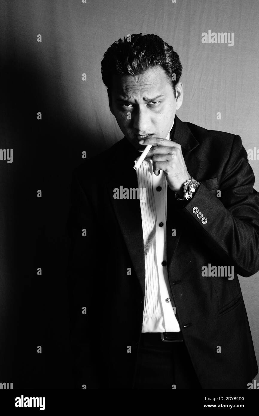 Man wearing suit smoking cigarette Black and White Stock Photos ...
