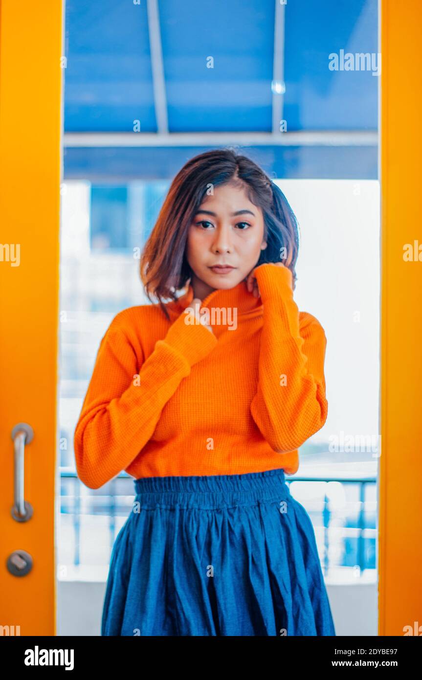 Portrait Of Young Woman Standing Against Door Stock Photo - Alamy