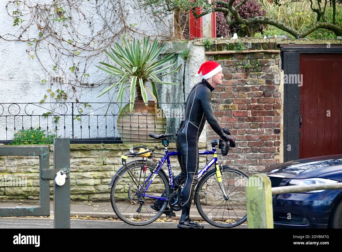 Elderly man cycling wearing wetsuit and Santa’s hat at Hampstead Men’s ...