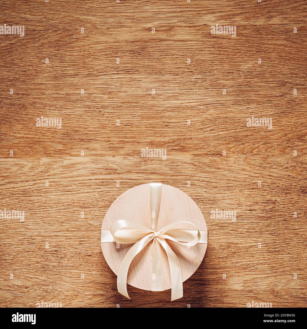 Gift in wooden box with light cream ribbon bow on oak table Stock Photo ...