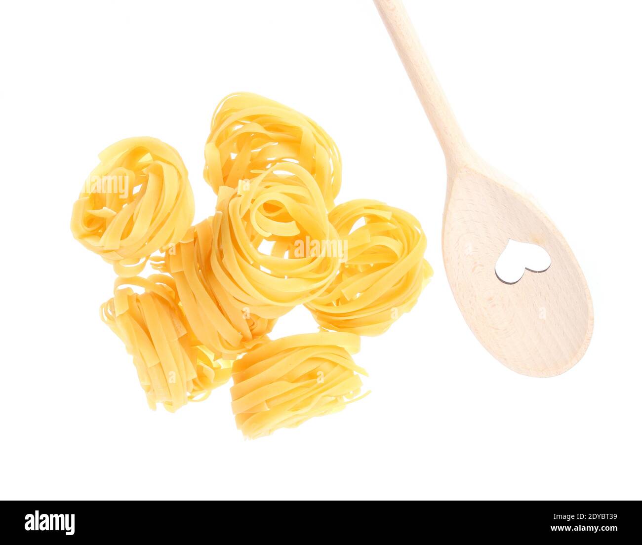 Raw dry tagliatelle noodle with wooden spoon close up isolated on white ...