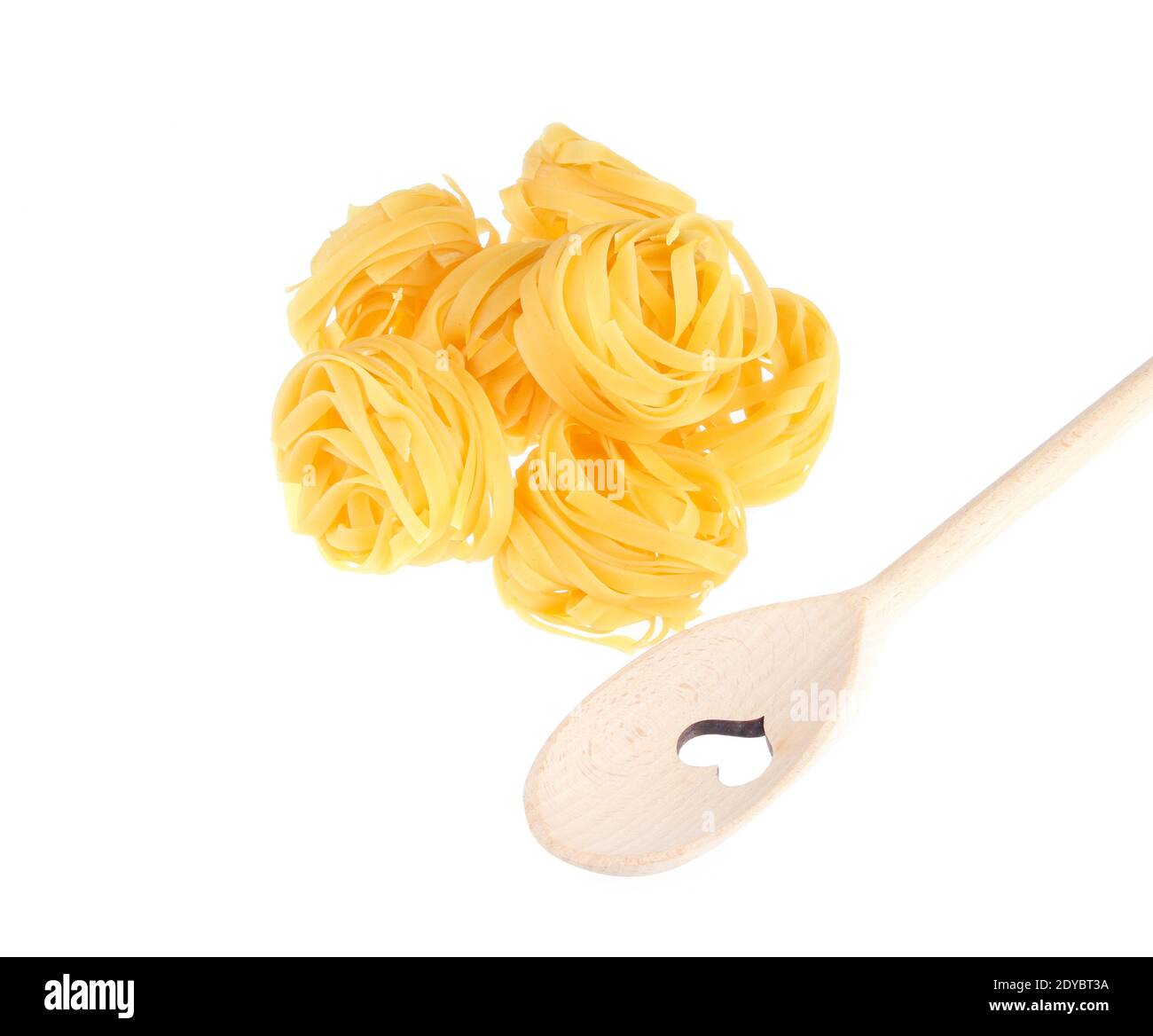 Raw dry tagliatelle noodle with wooden spoon close up isolated on white ...