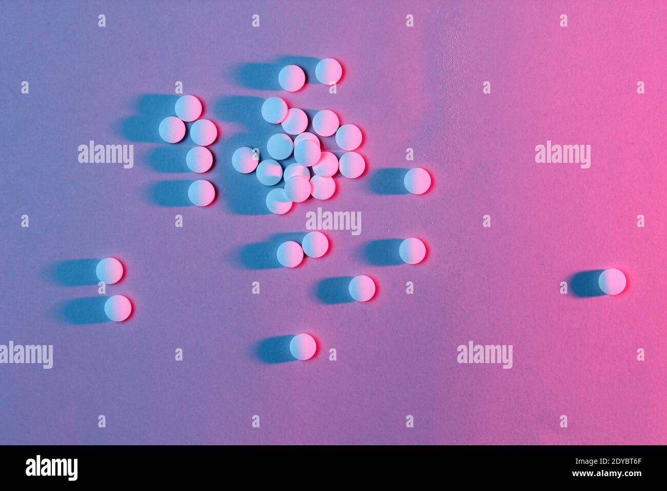 Addiction. The concept of dependence. Many white pills with red-blue ...