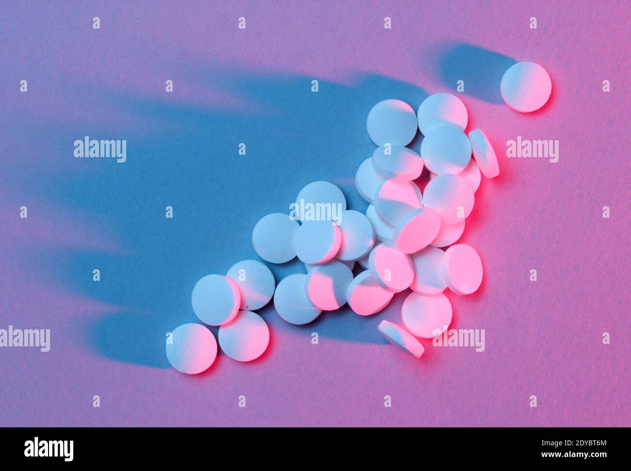 Addiction. The concept of dependence. Many white pills with red-blue ...