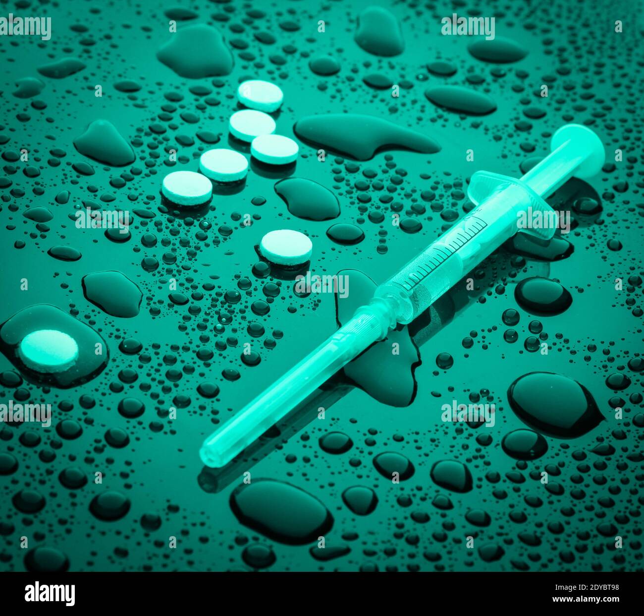 Drug concept, addiction. Syringe and pills on dark background with ...