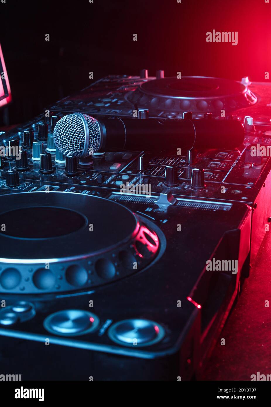 Night club, nightlife concept. Disco. Microphone on DJ remote. Neon red ...