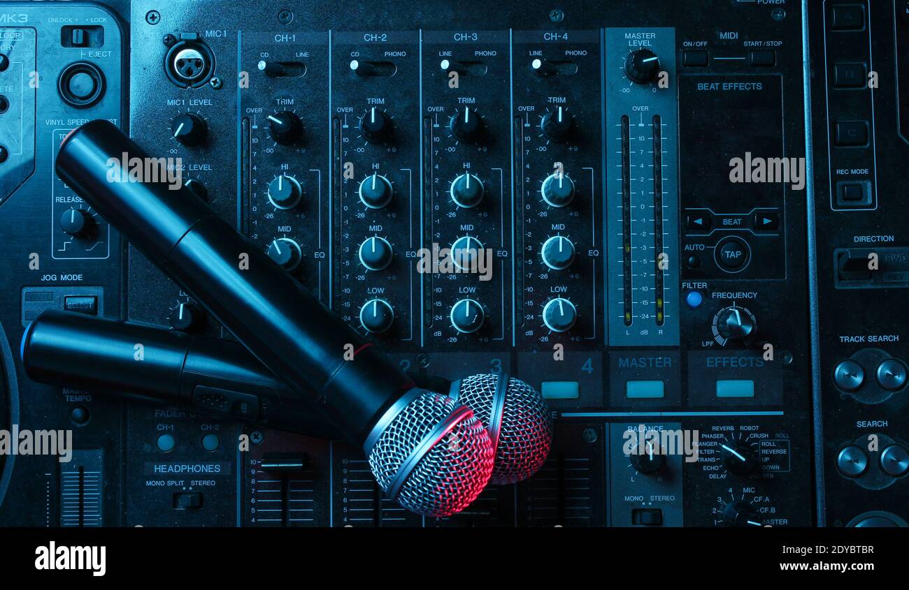 Night club, nightlife concept. Disco. Two microphone on DJ remote. Neon ...