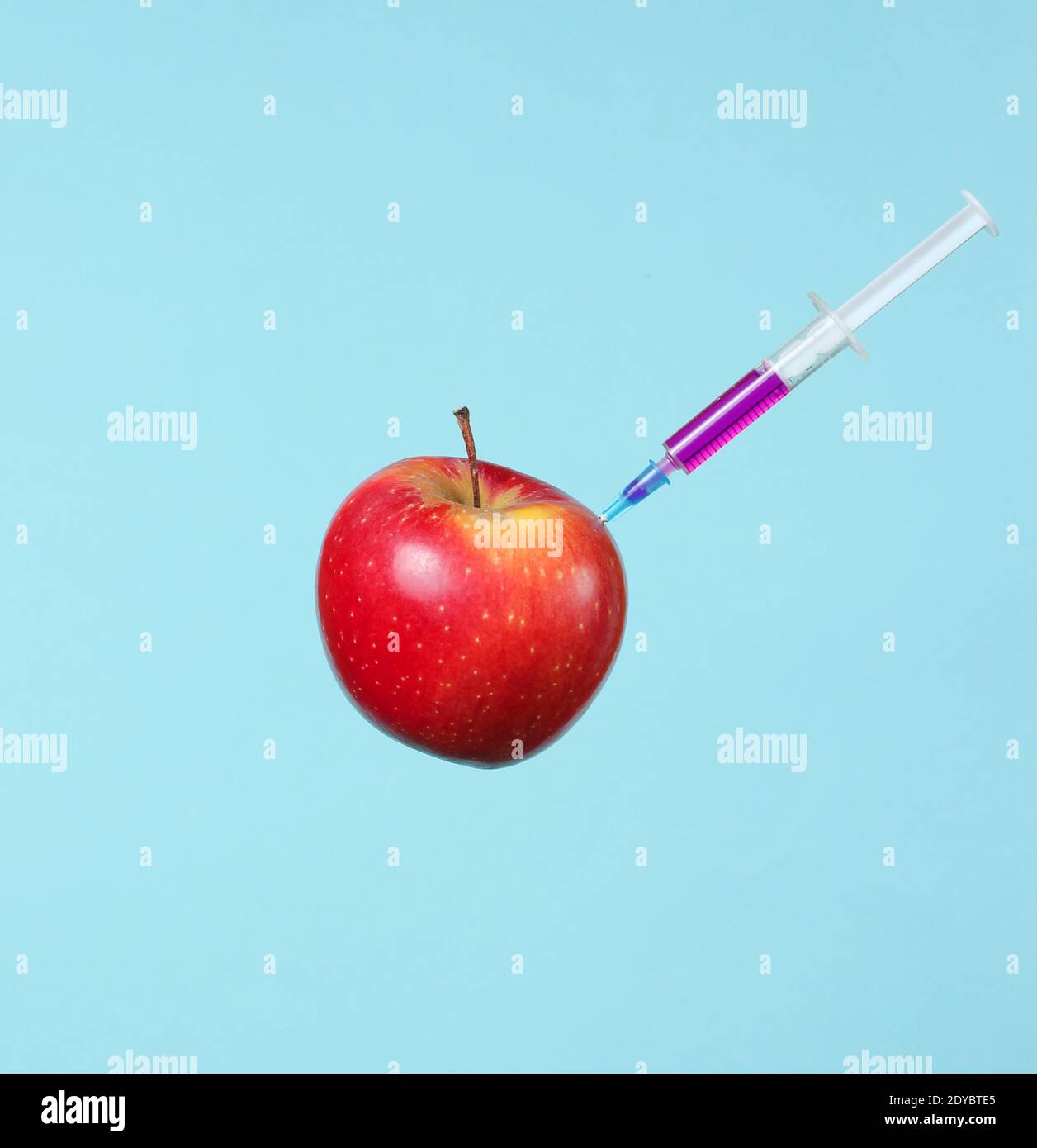 Genetically modified Red Apple with syringes on blue background ...