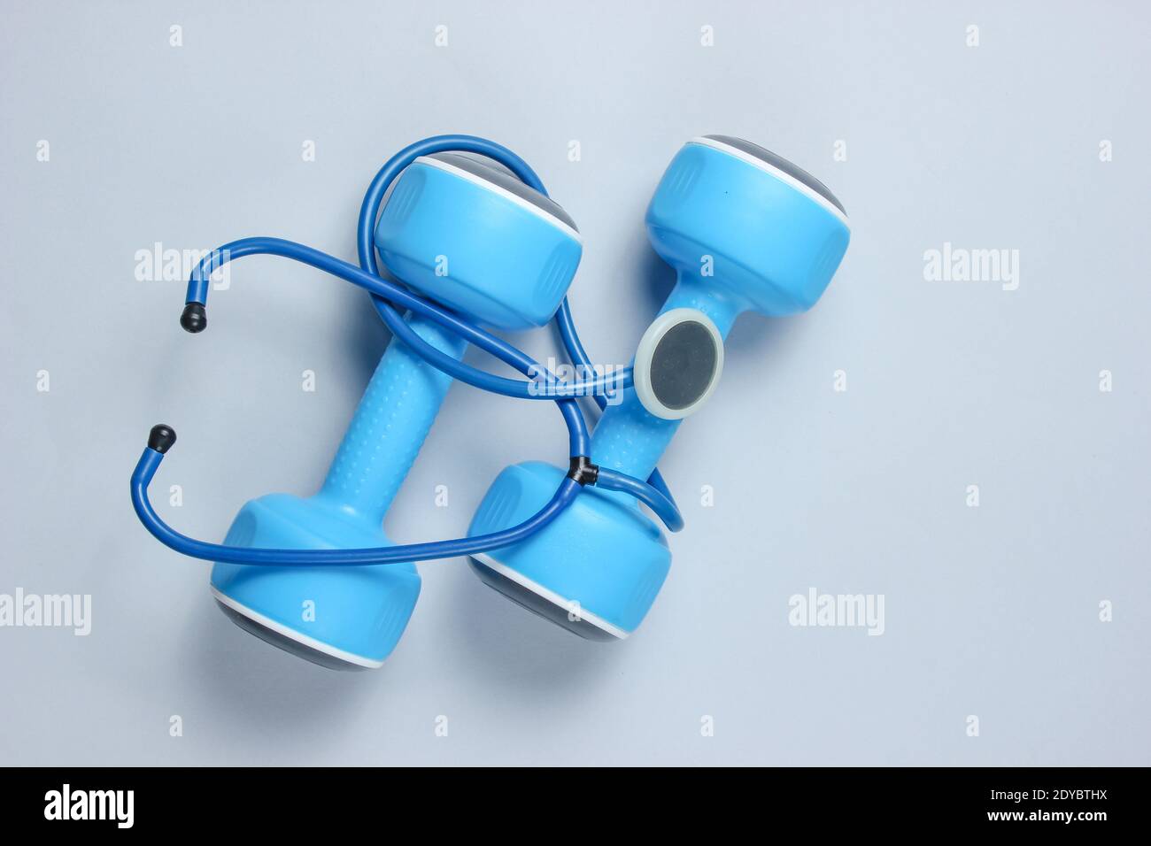 Healthy heart and strong muscles. Blue plastic dumbbells and ...