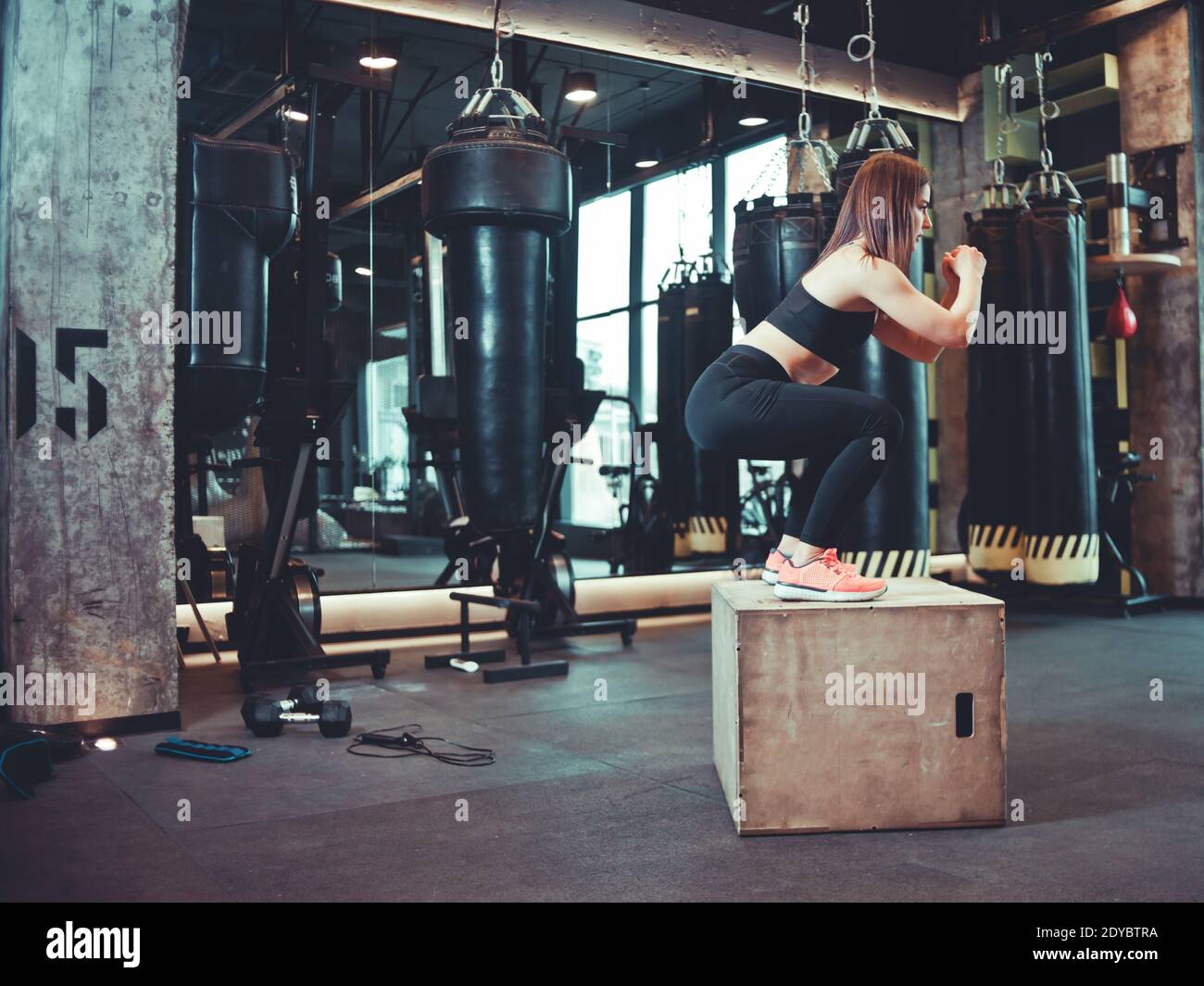 Fitness woman jumping on wooden box training at the gym, workout ...