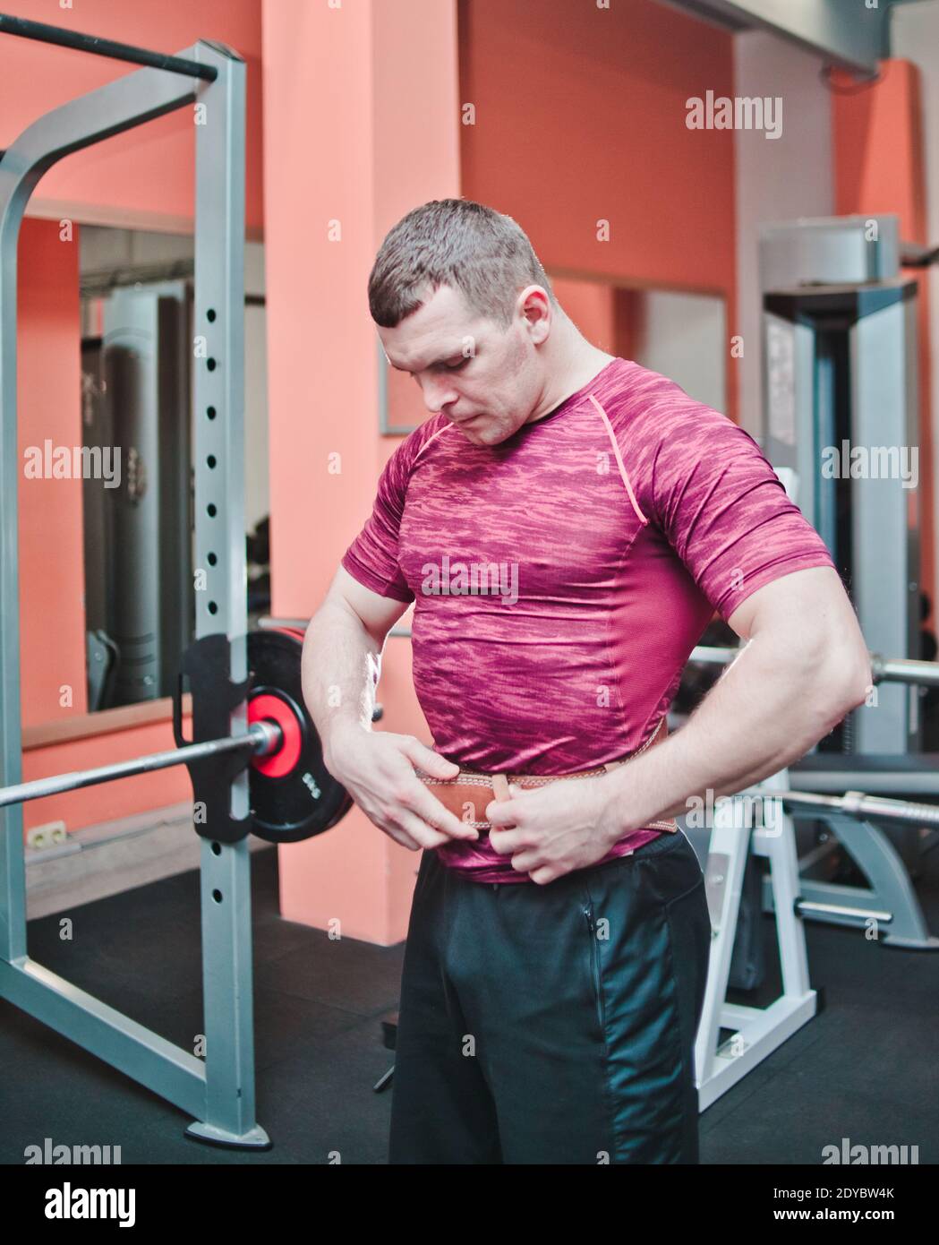 Athletic man puts on a strength belt before a heavy workout Stock Photo ...