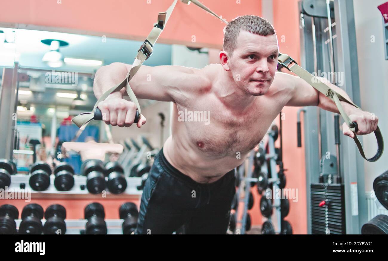 Strong man does crossfit push ups with fitness straps at gym Stock ...