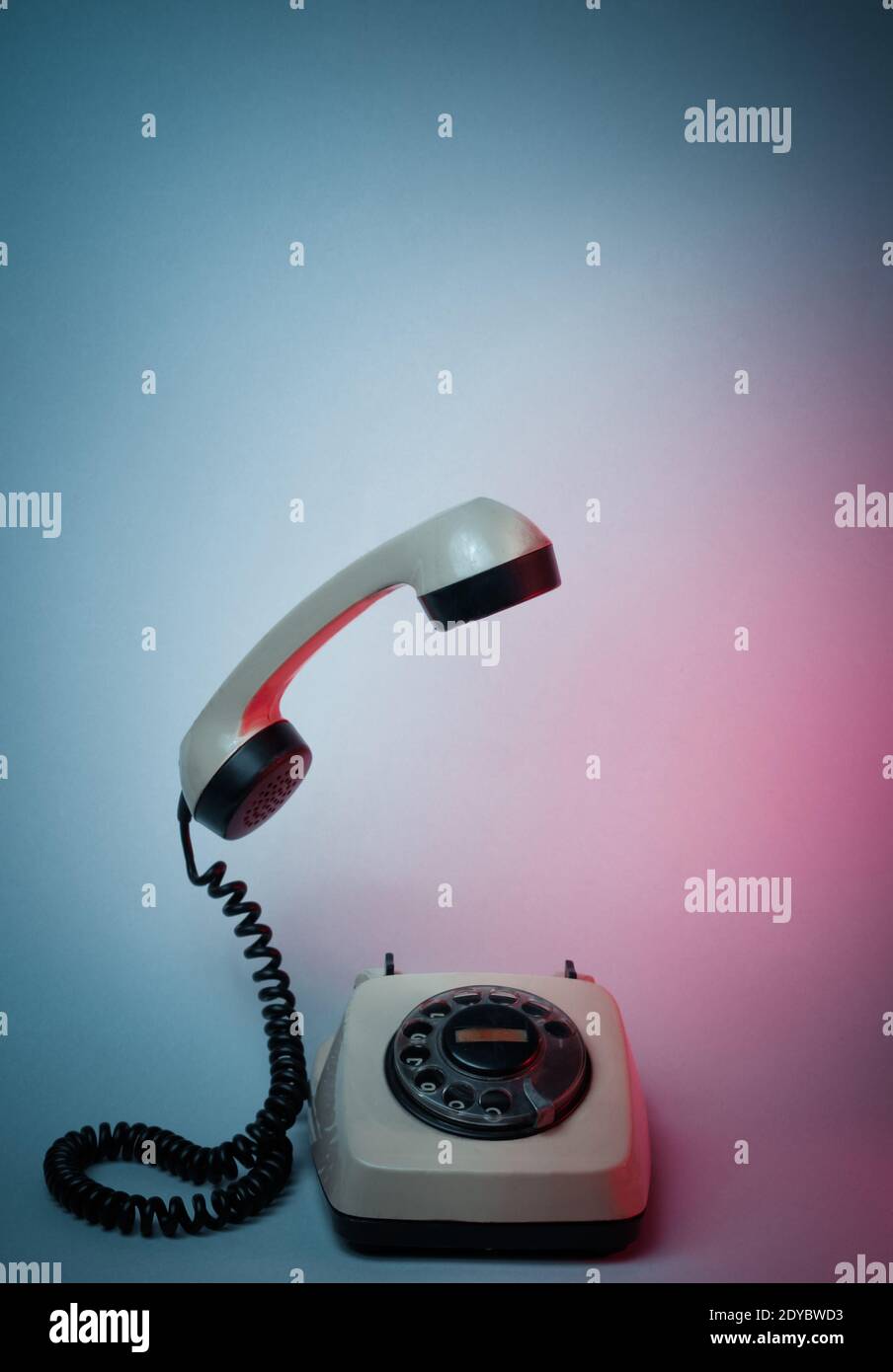 Old style rotary telephone with soaring telephone handle, neon light ...