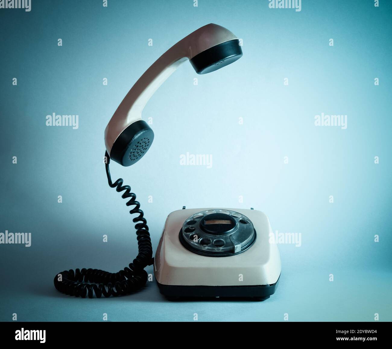 Old style rotary telephone with soaring telephone handle, blue neon ...