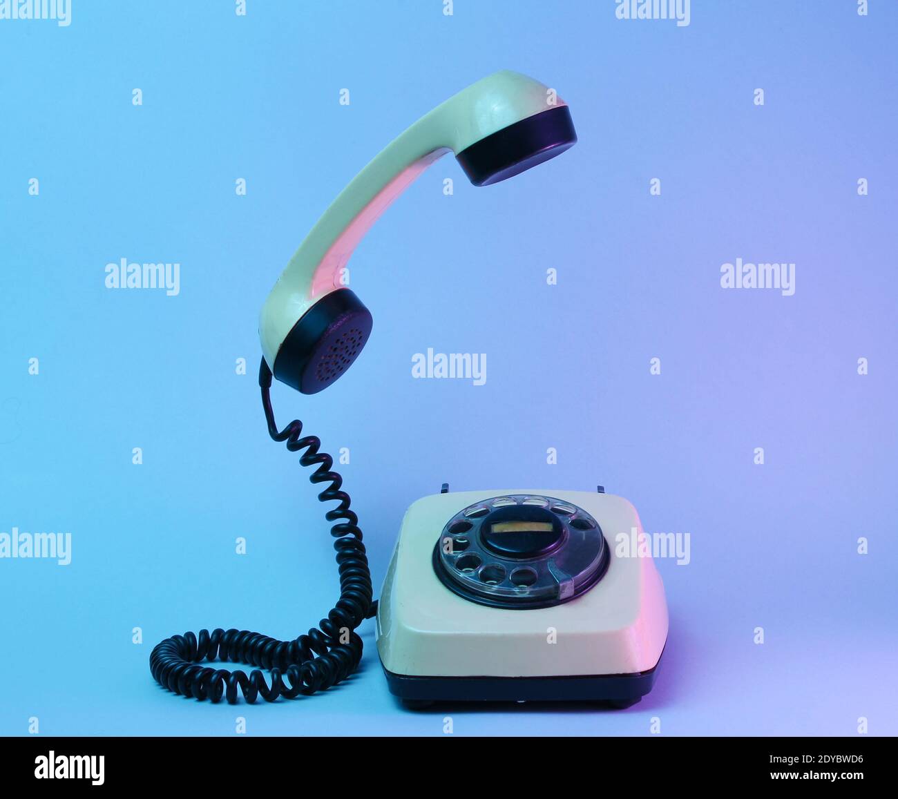 Old style rotary telephone with soaring telephone handle, neon light ...