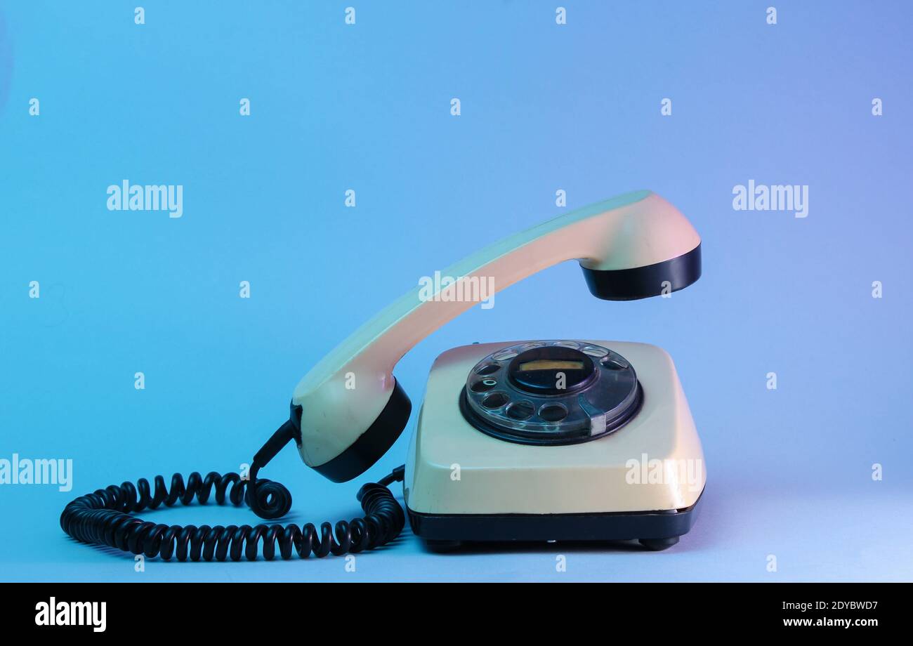 Old style rotary telephone with soaring telephone handle, neon light ...