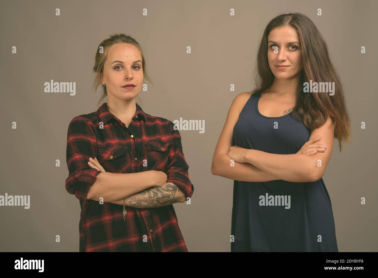Two young beautiful woman friends against gray background Stock Photo ...