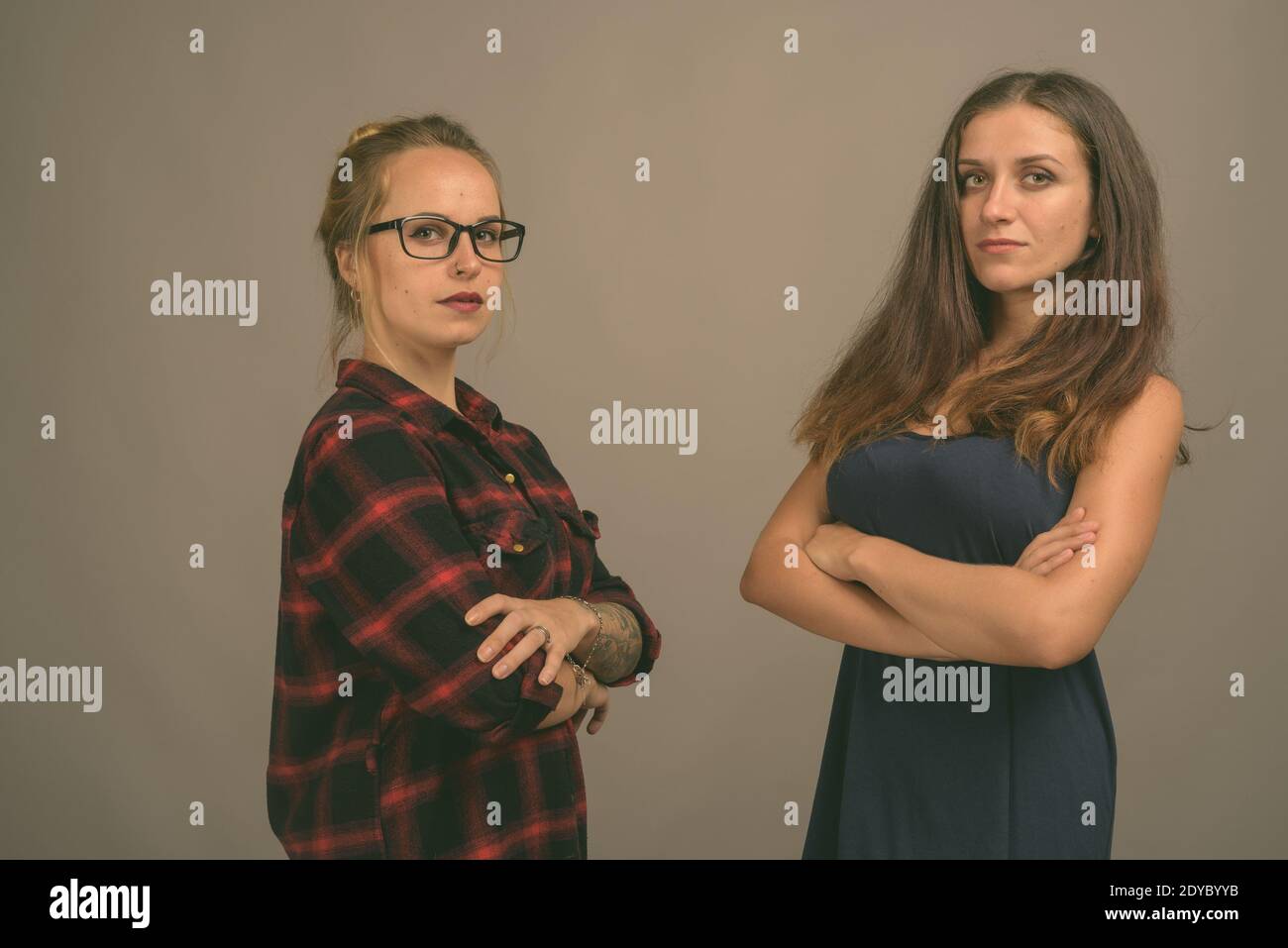 Two young beautiful woman friends against gray background Stock Photo ...