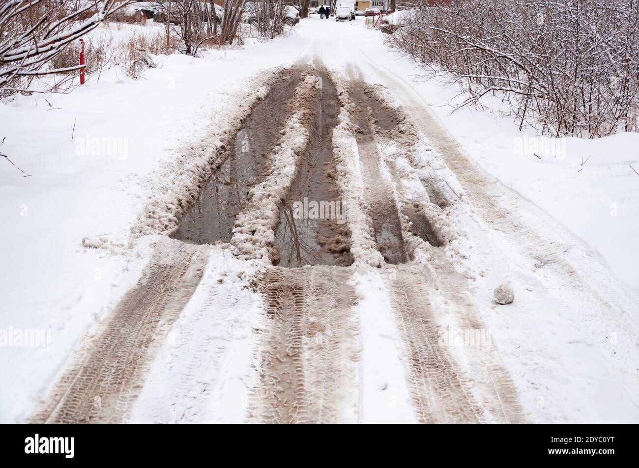Melted snow on an asphalt surface with deep standing water and snow on ...