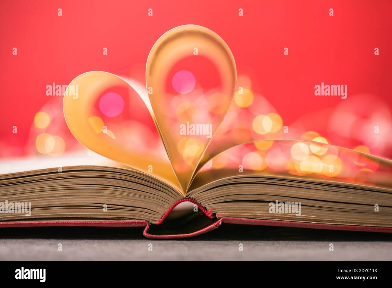 Book with love symbol on red background, heart shape from paper book ...