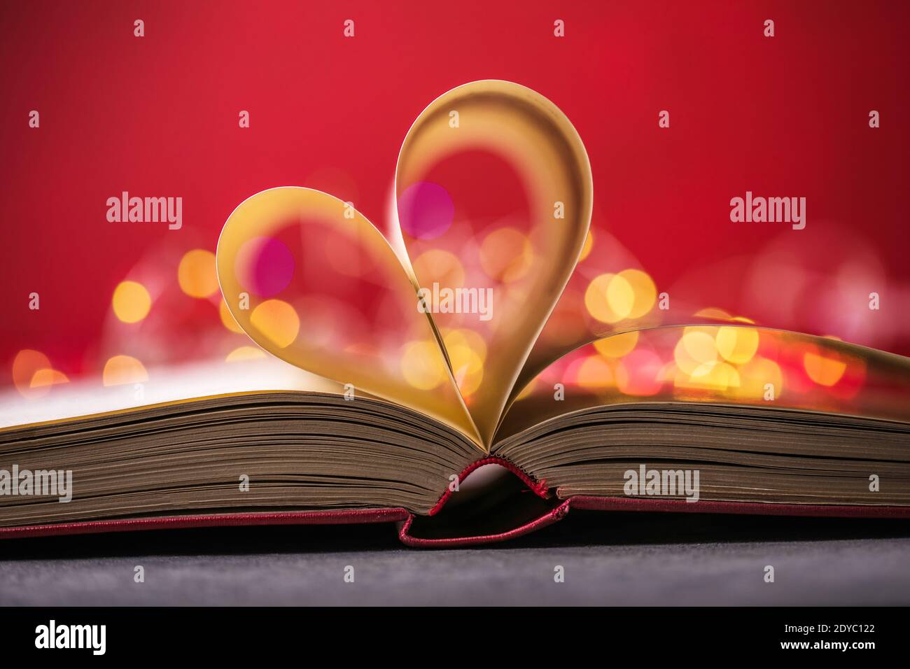 Book with love symbol on red background, heart shape from paper book ...