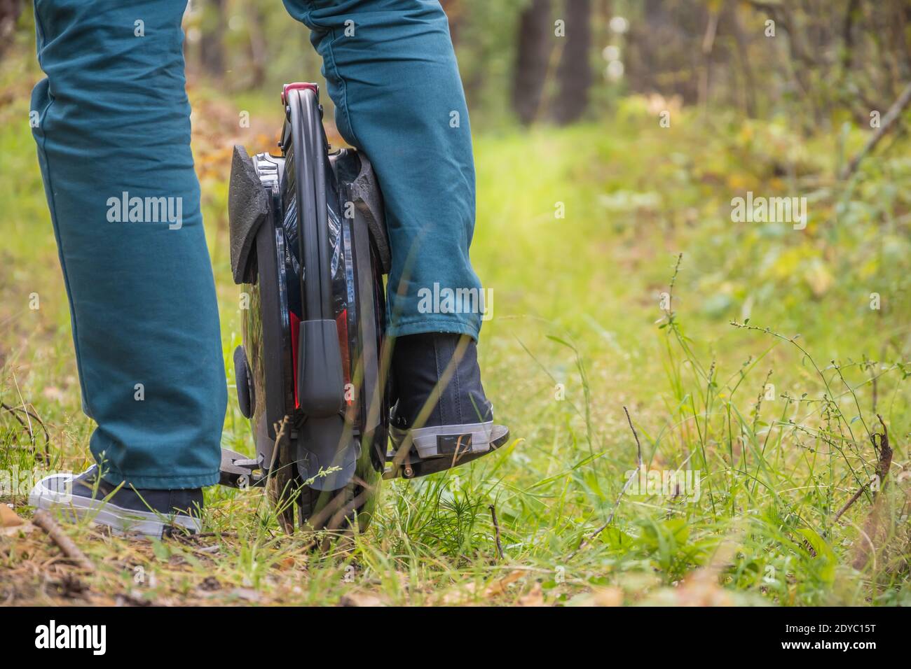 Rear view of men's legs on an electric unicycle in the forest Stock ...