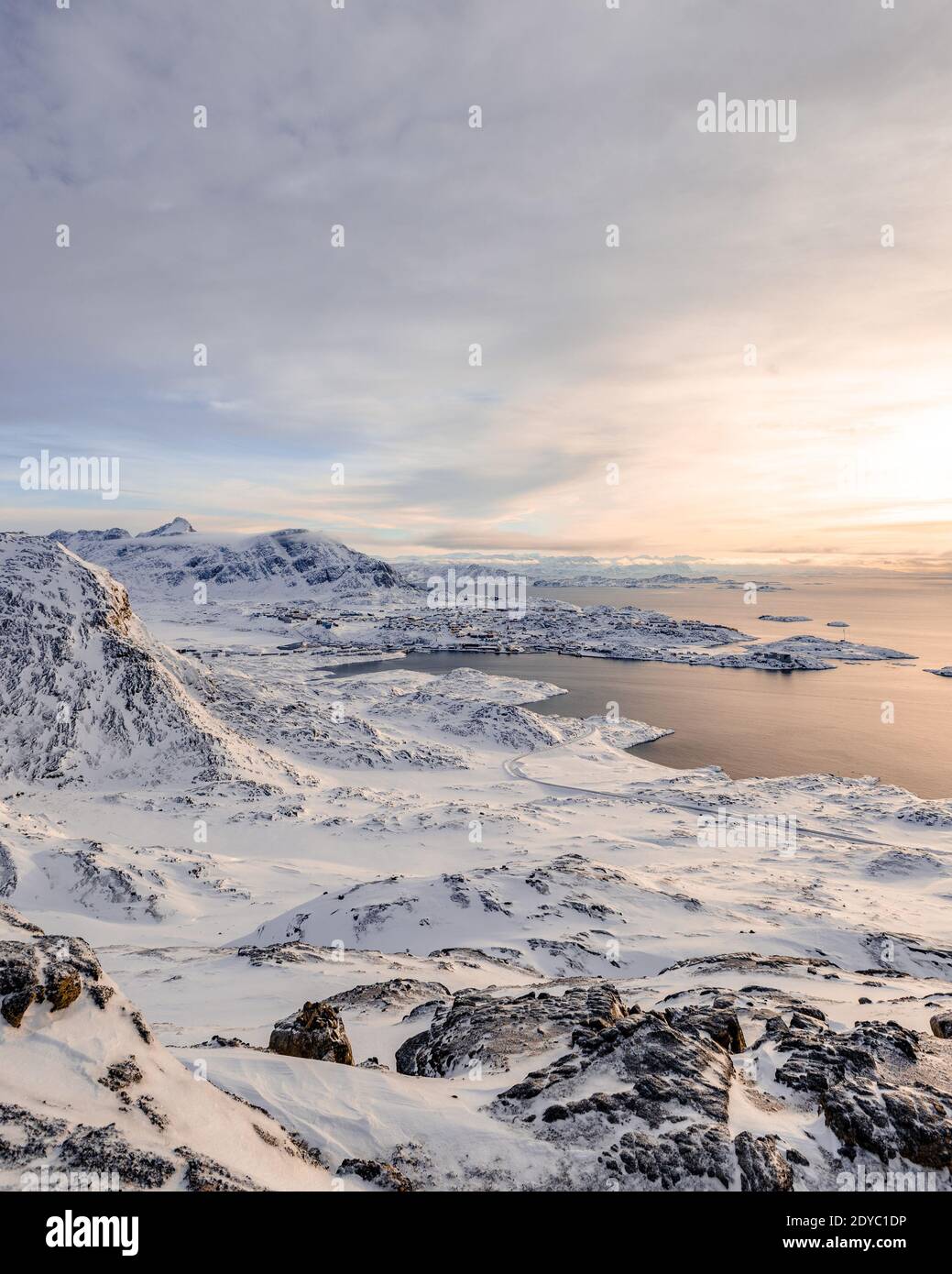 A vertical shot of frozen mountains and lands near a frozen lake ...