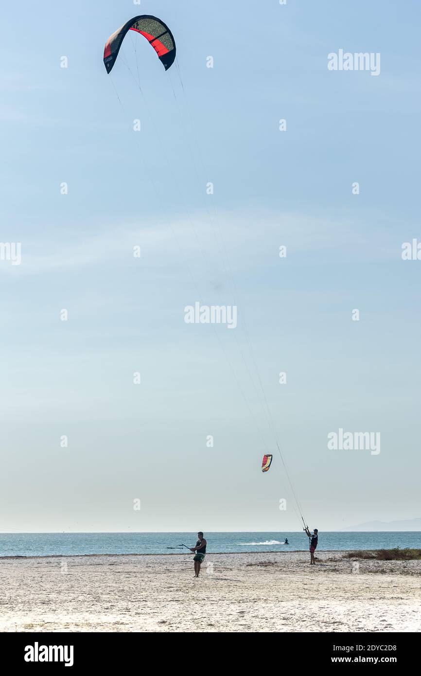 A vertical shot of two male doing skysurfing on a Caribbean island ...