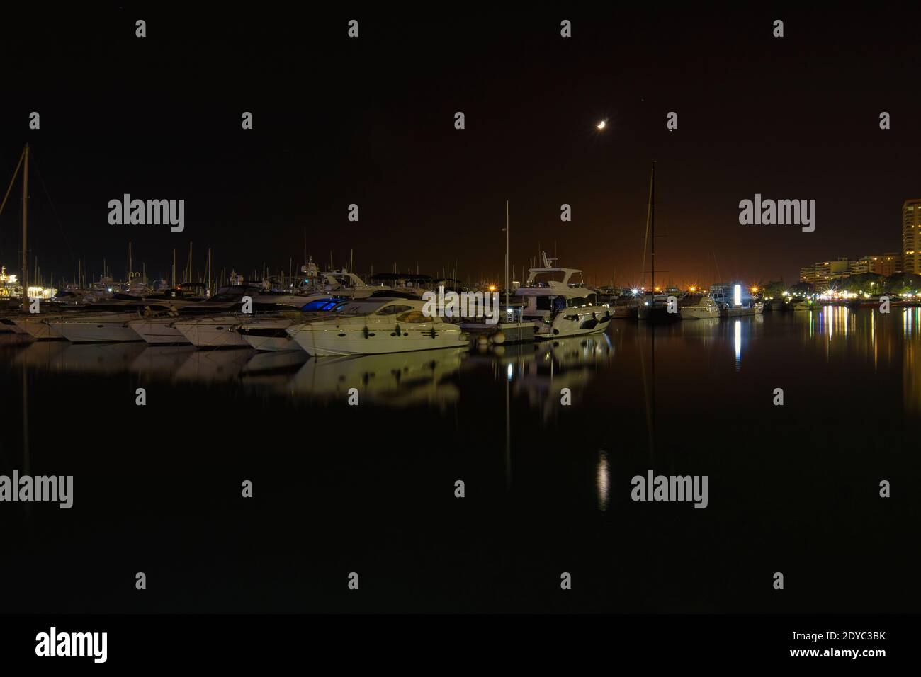 port in crescent moon night with reflections in the sea in spain Stock ...