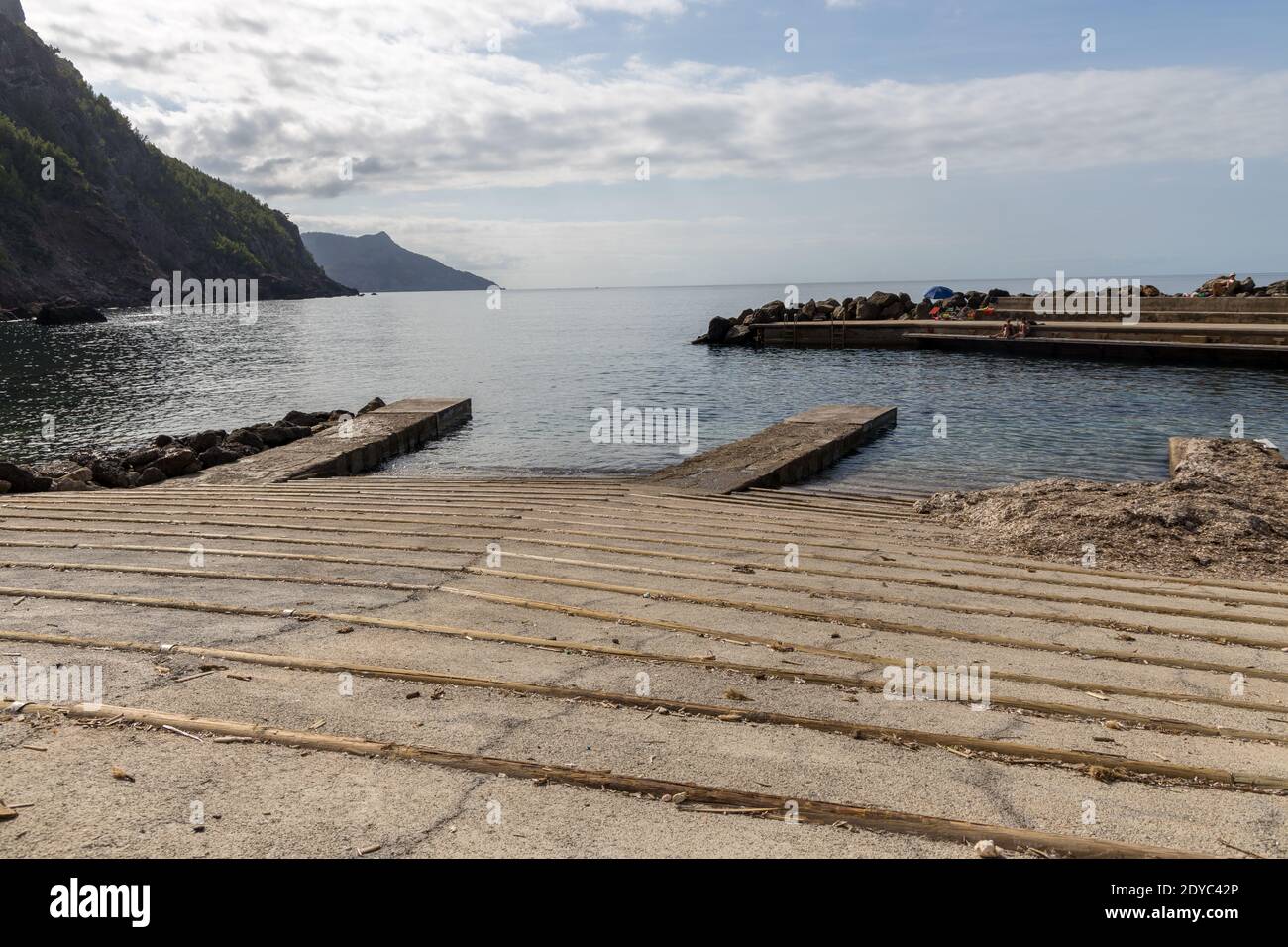 The beautiful ocean surrounded by hills and piers captured in Mallorca ...