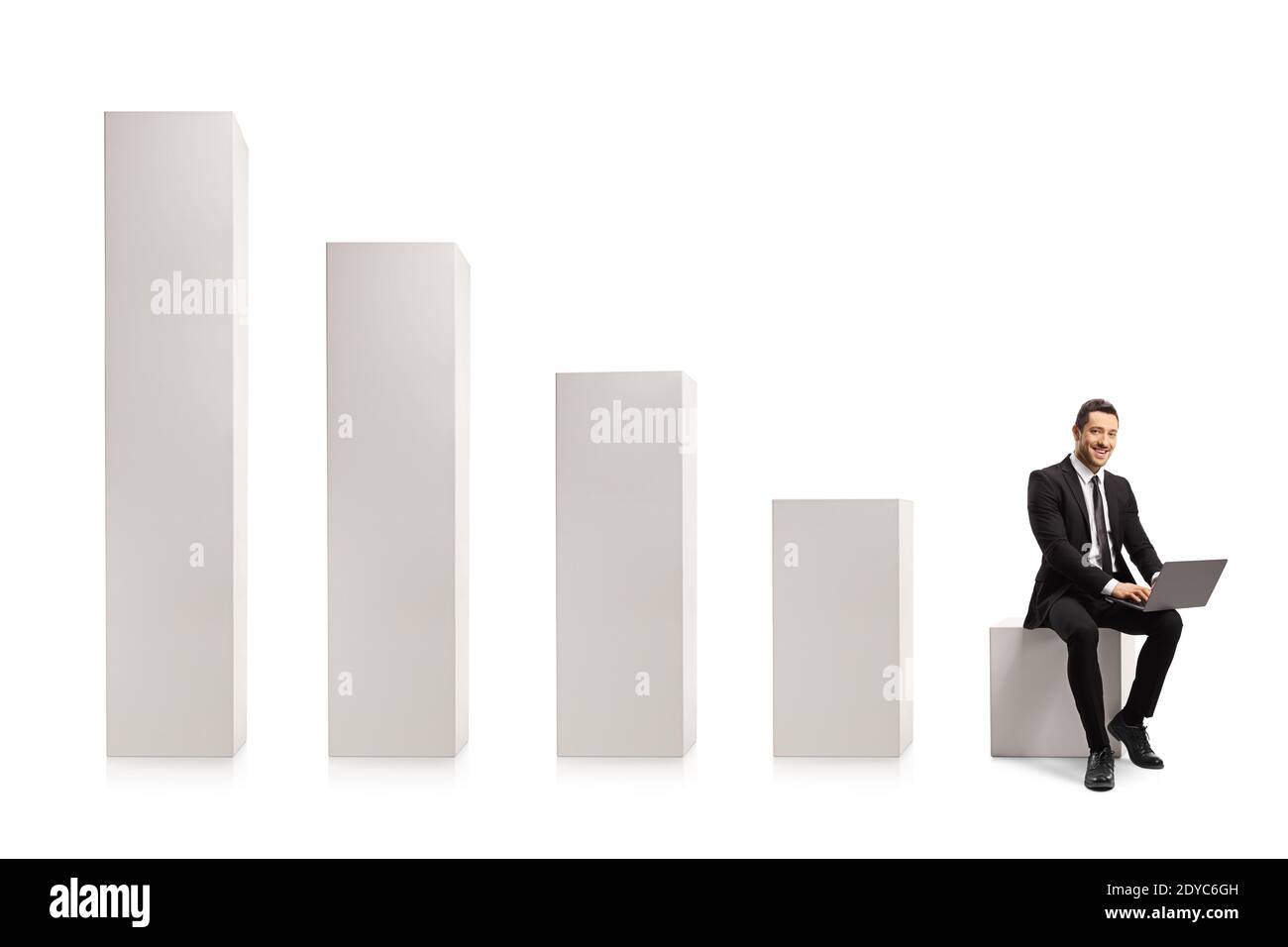 Successful businessman with a laptop computer sitting on a column ...