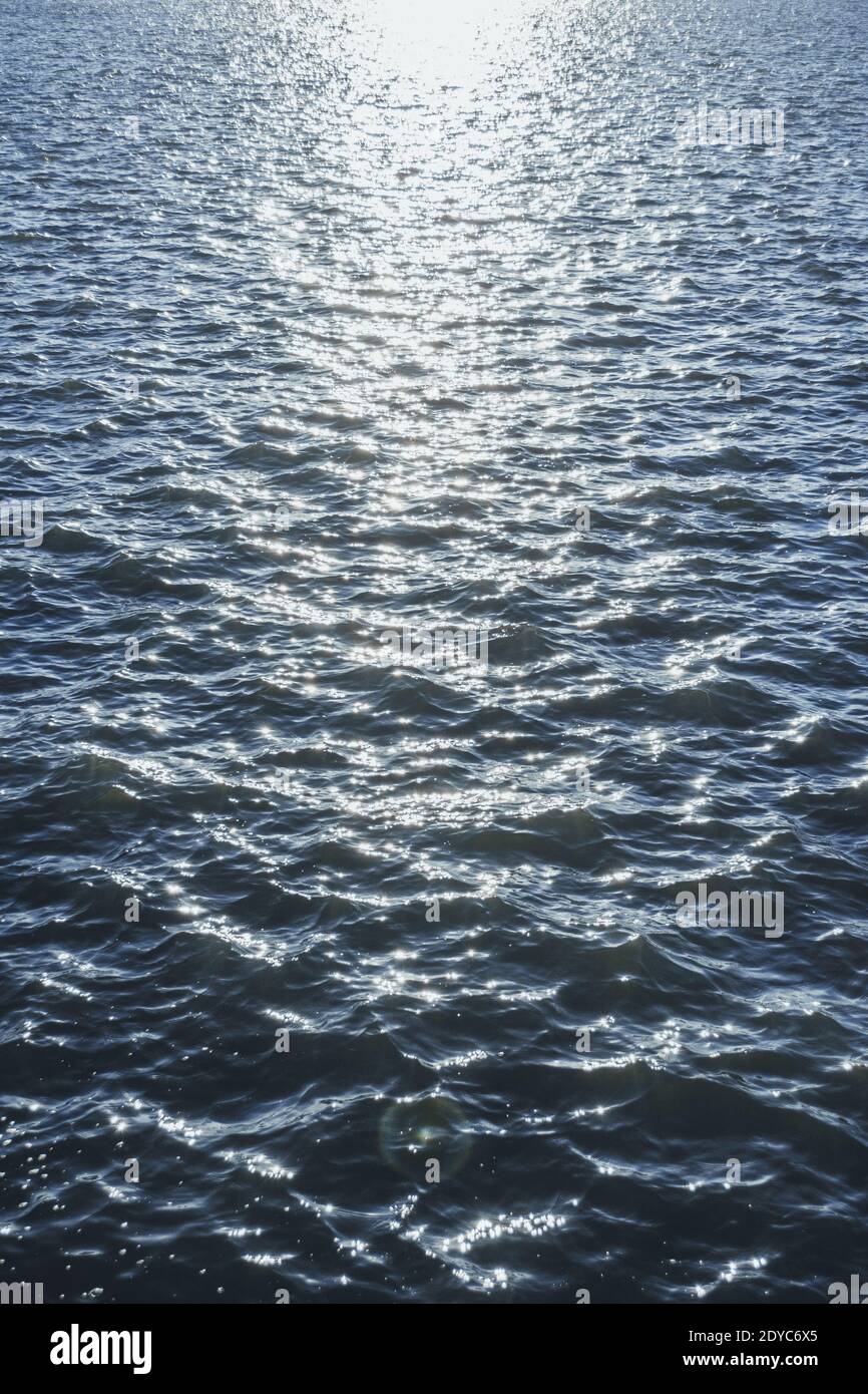 A vertical shot of seawater texture, sunlight reflecting on the surface ...
