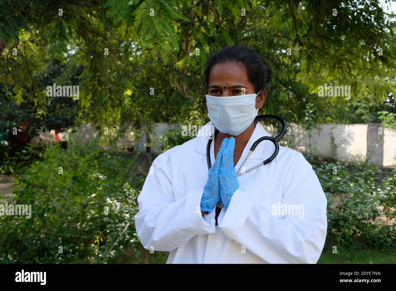 An Indian doctor with a stethoscope wearing a mask and praying Stock ...